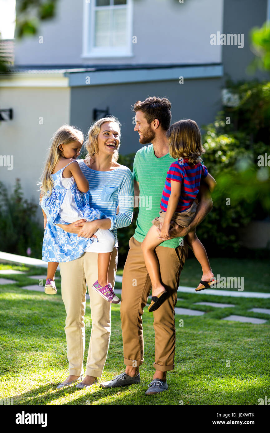 Parents carrying children in yard Stock Photo - Alamy