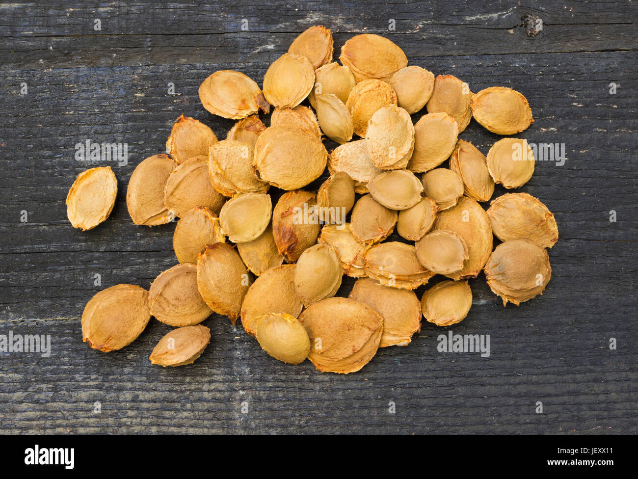 Bitter apricot kernels in wooden background Stock Photo - Alamy