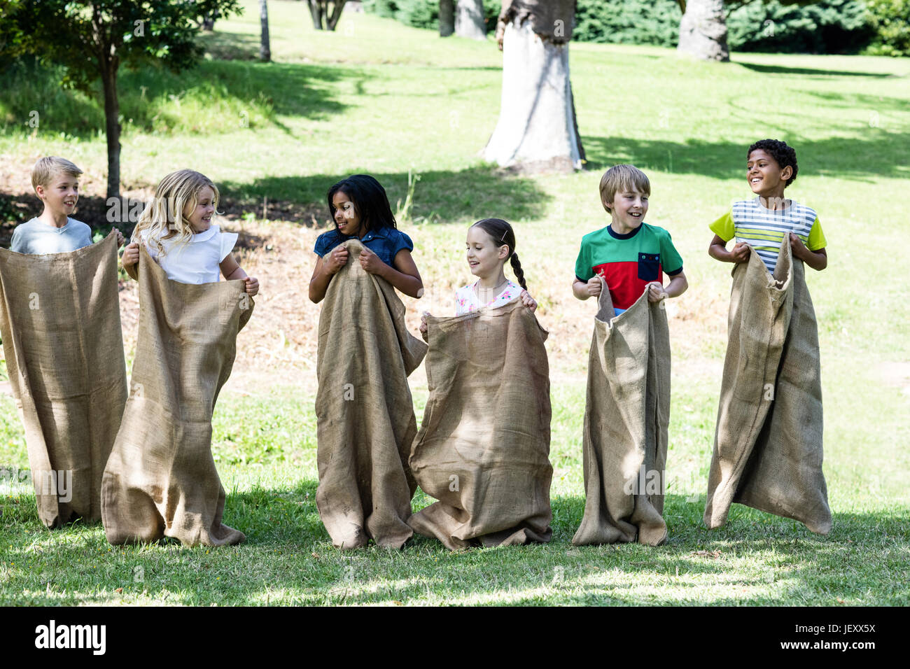 Children having a sack race in park Stock Photo - Alamy