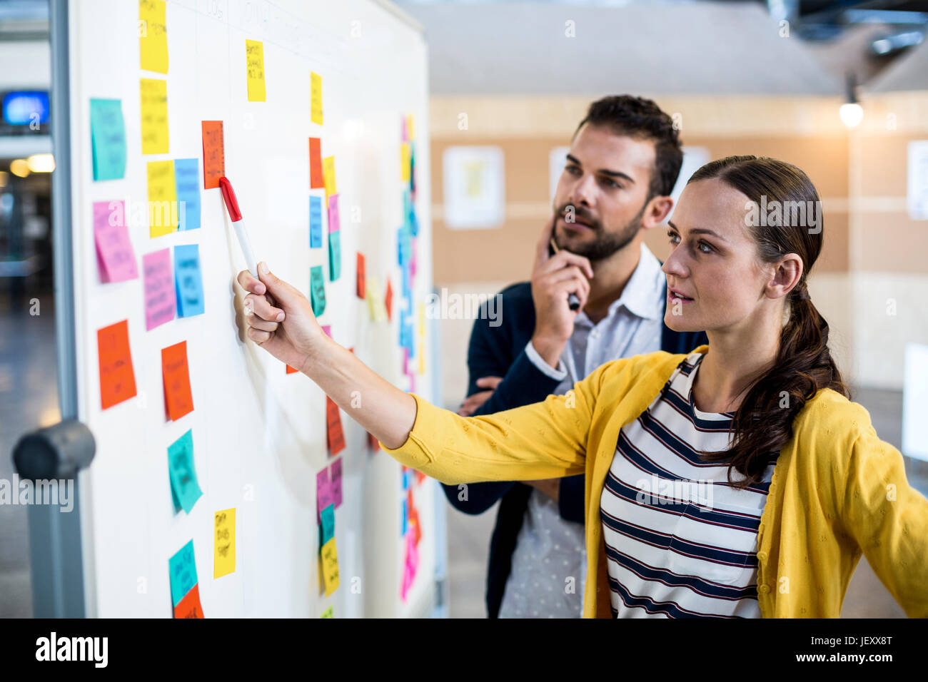 Colleagues looking at white board Stock Photo - Alamy