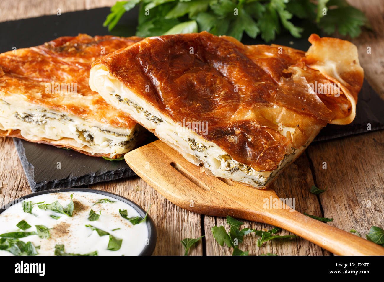 Tasty Turkish burek with spinach and cheese close-up on table ...