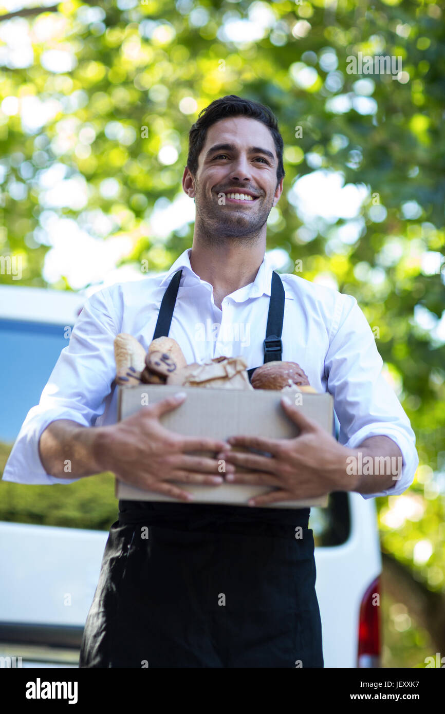 Happy delivery person carrying food package Stock Photo - Alamy