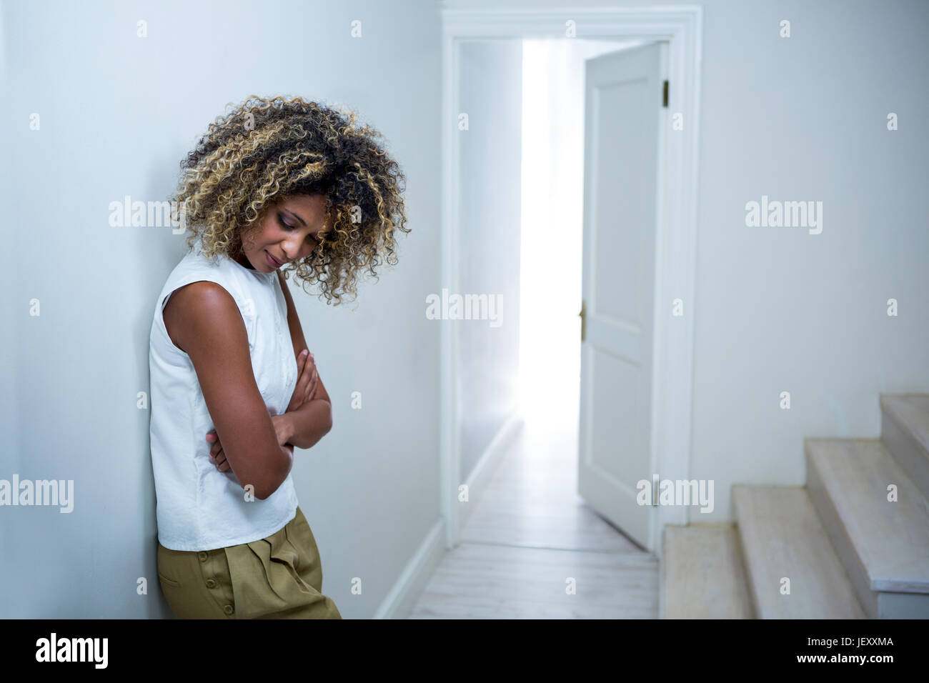 Tensed woman leaning on wall Stock Photo - Alamy
