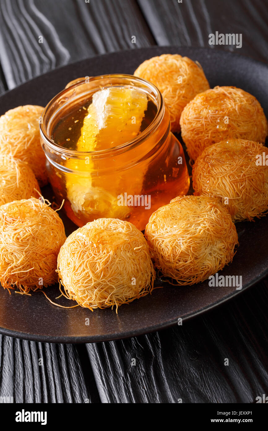 Delicious Middle Eastern kanafeh pastries with fresh honey close-up on ...