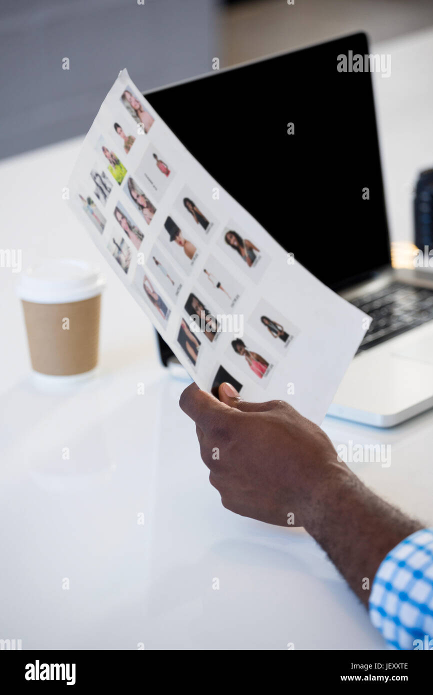 Man holding a chart with laptop on desk Stock Photo - Alamy