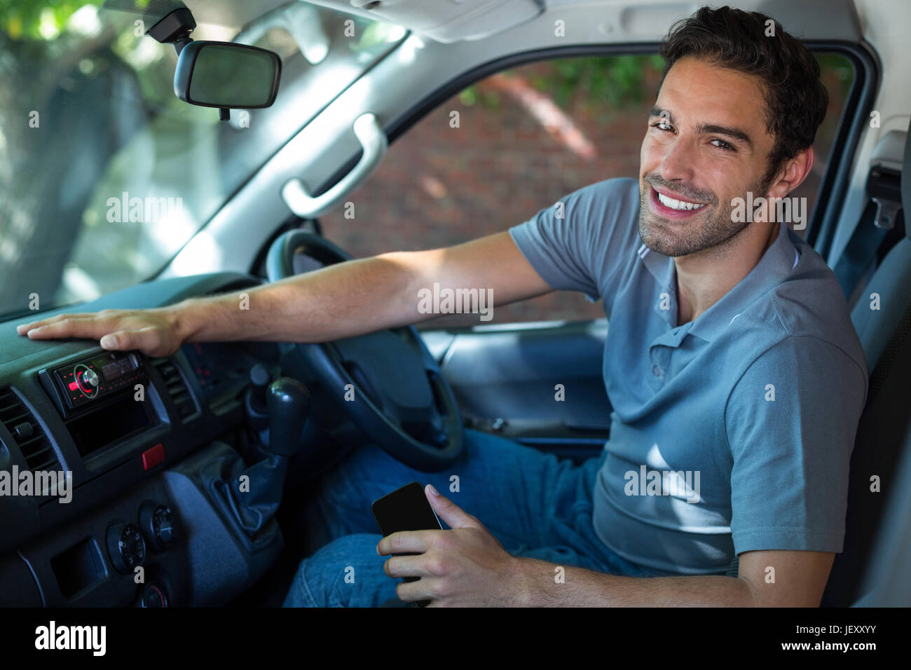 Smiling driver sitting in car Stock Photo - Alamy