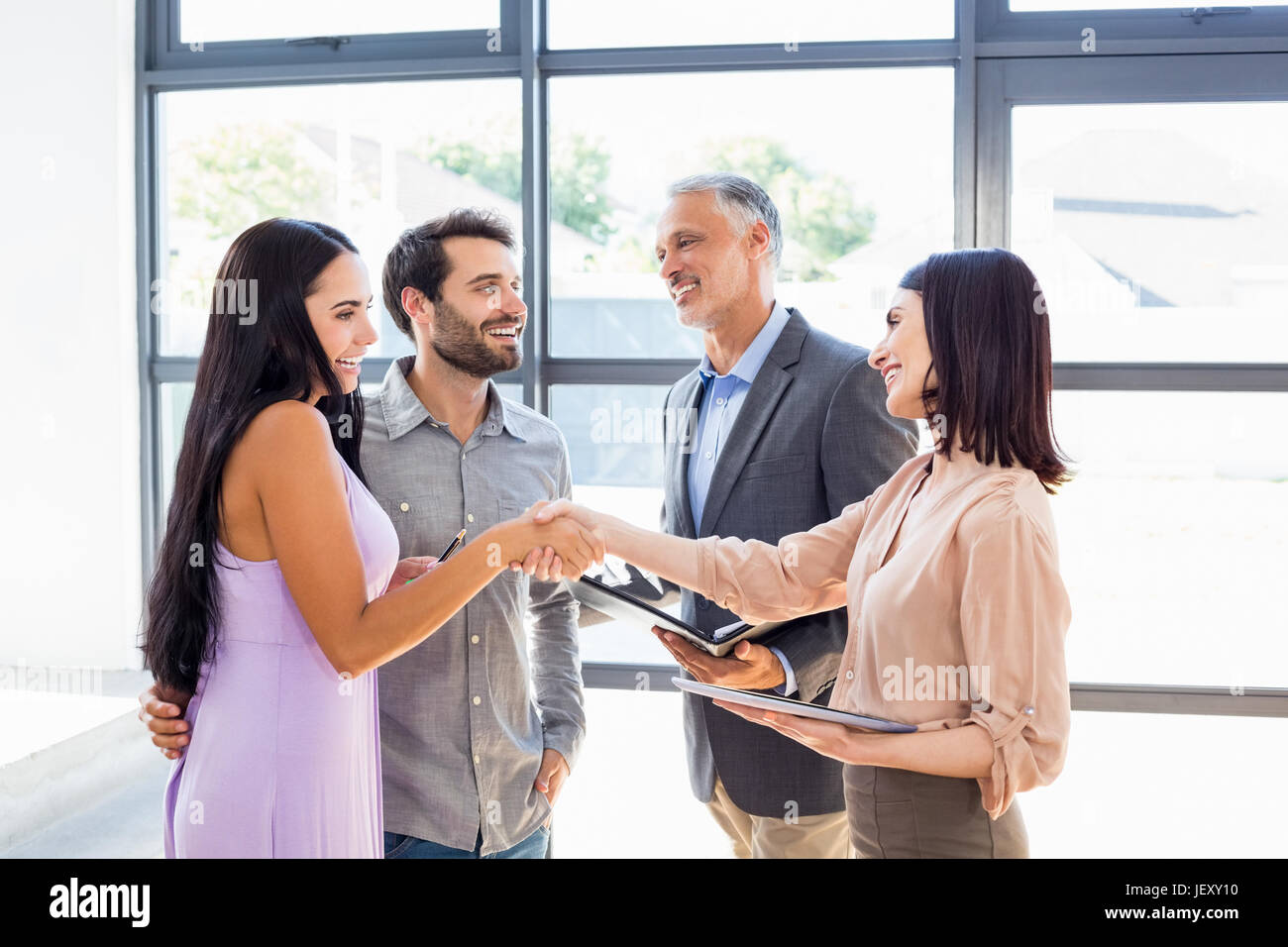Young happy couple giving handshake hi-res stock photography and images ...