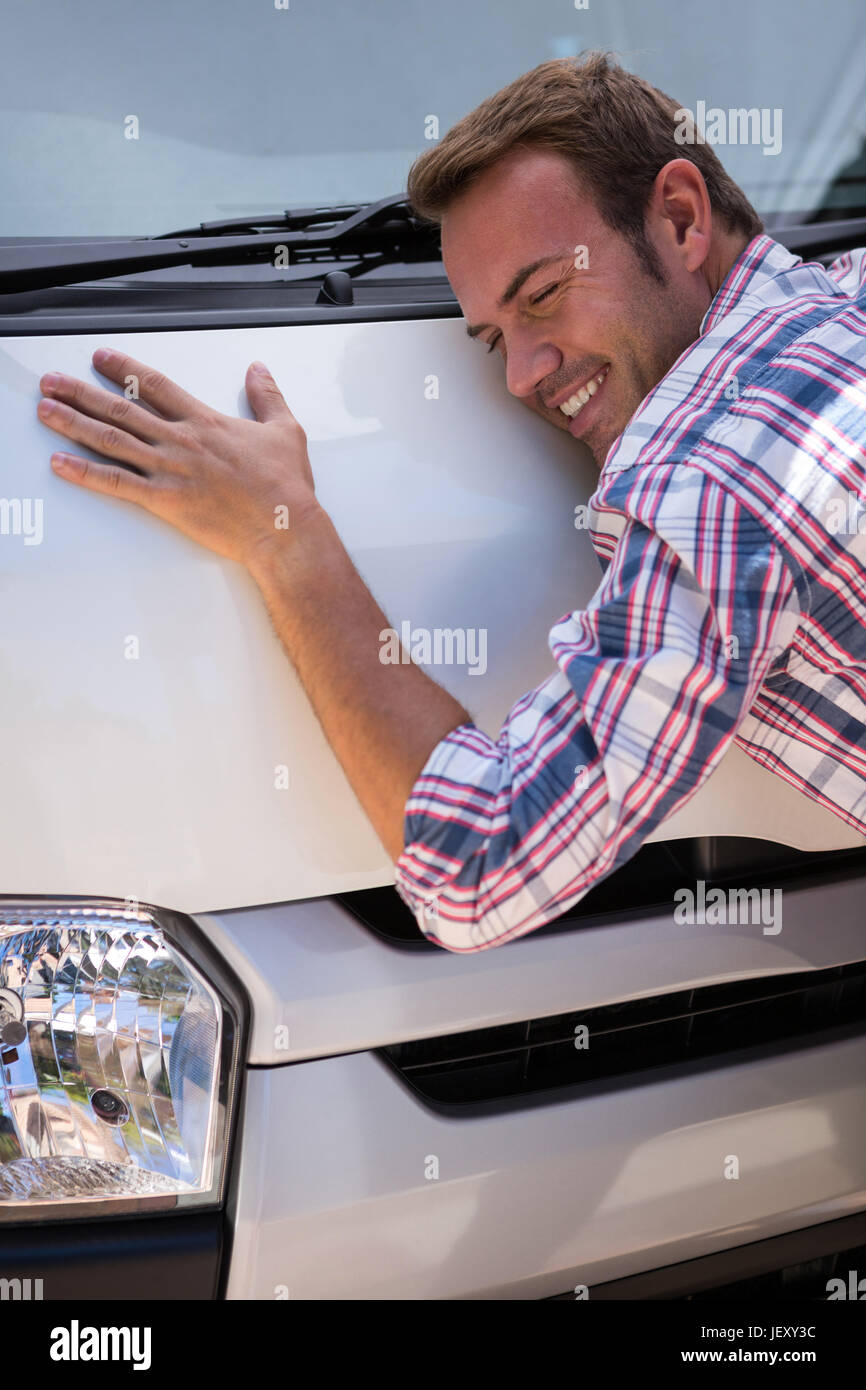 Young man hugging his car Stock Photo - Alamy