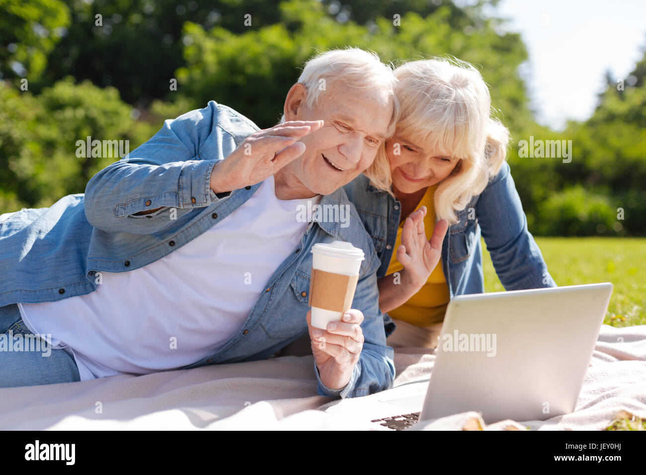 Happy elderly people looking at screen of laptop Stock Photo - Alamy