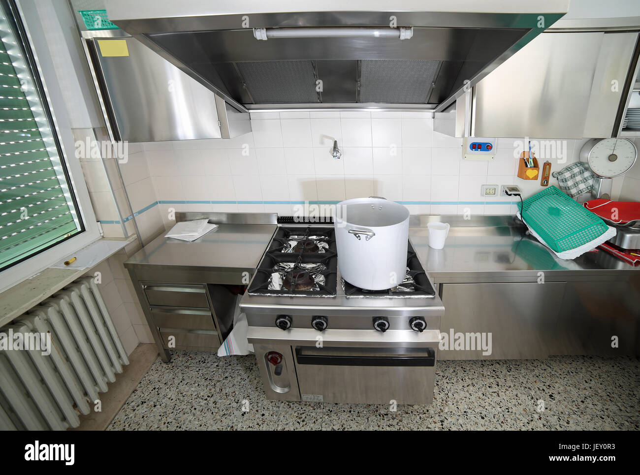 commercial kitchen with big cauldron of aluminium and the burners of ...