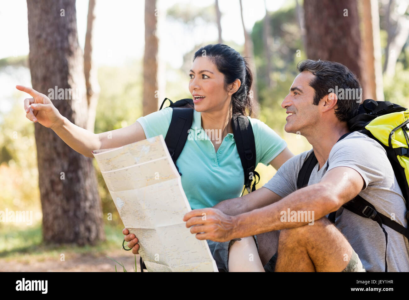 Couple pointing and holding a map Stock Photo - Alamy
