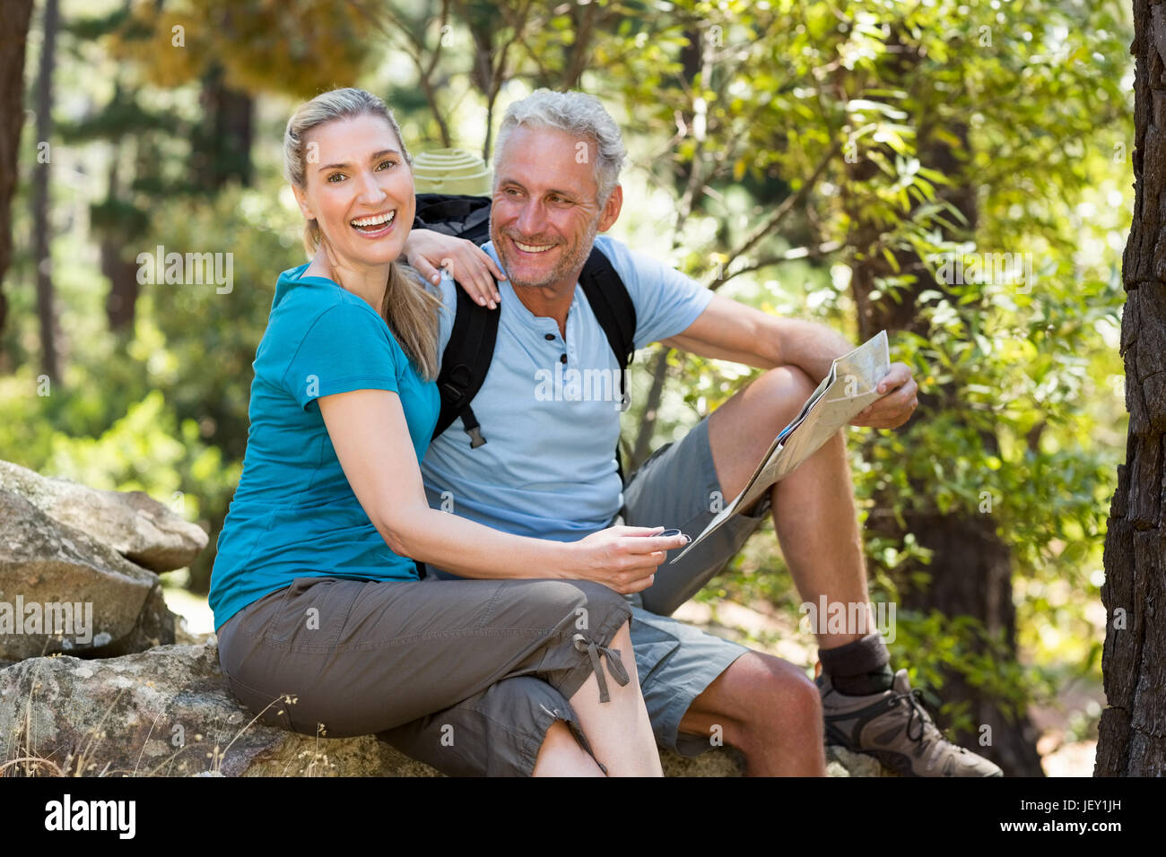Couple smiling and holding a map Stock Photo - Alamy