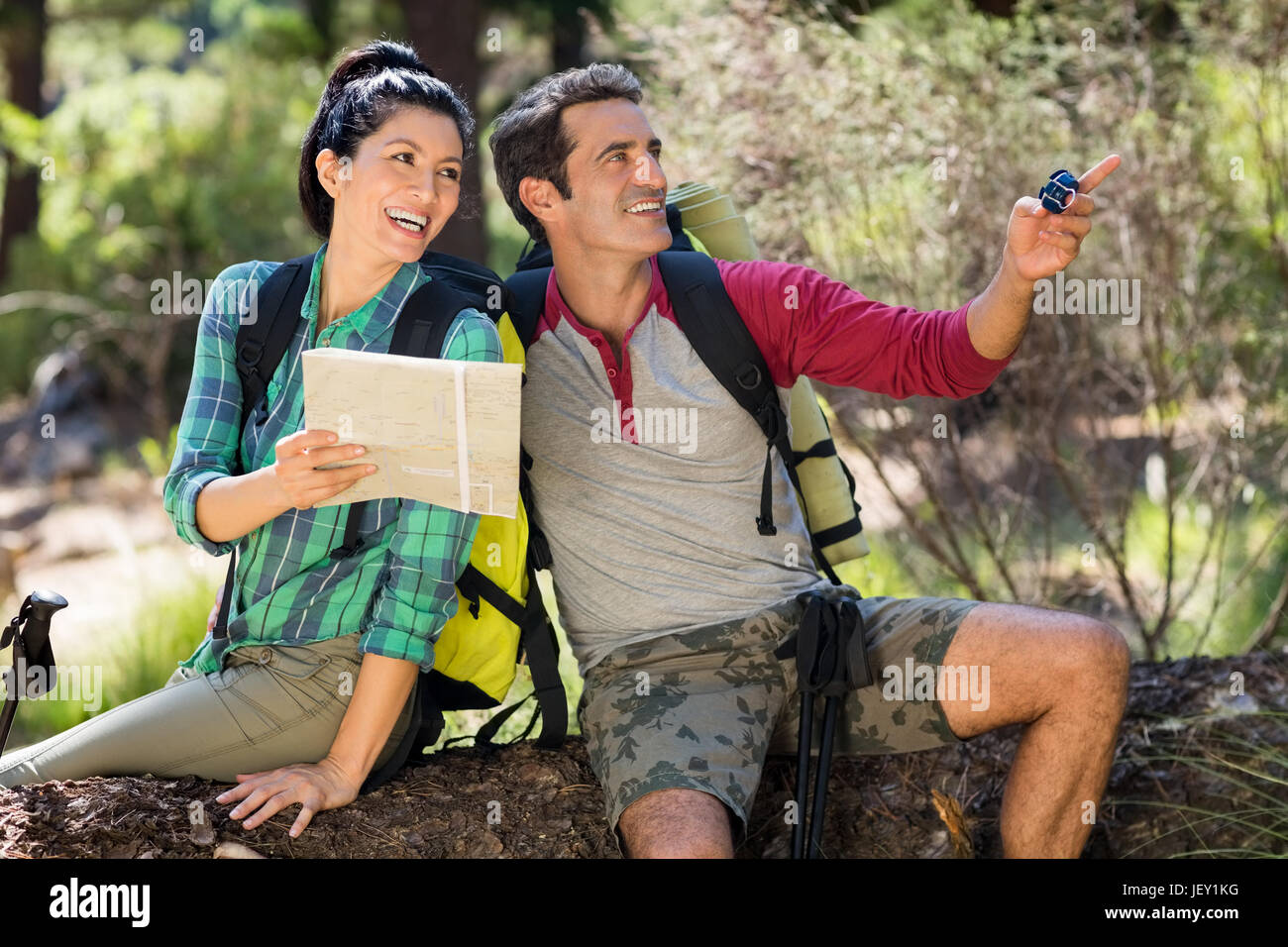 couple smiling and holding map and compass Stock Photo - Alamy