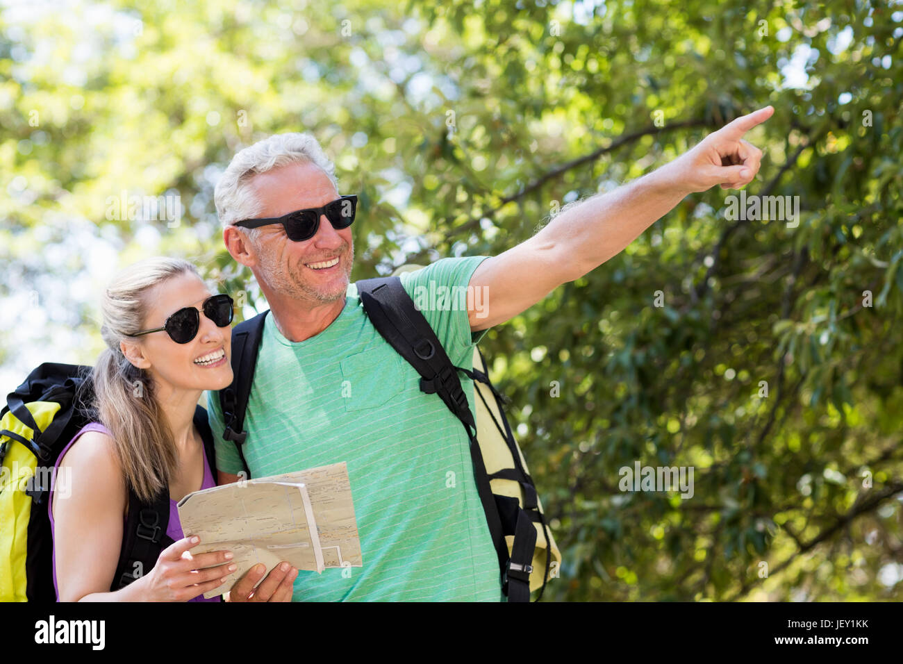 Couple pointing and holding a map Stock Photo - Alamy