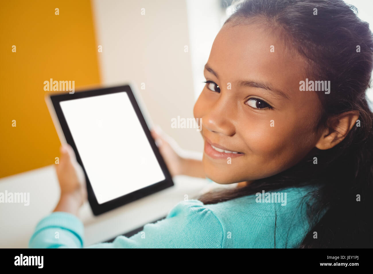 Girl smiling and using a tablet Stock Photo - Alamy