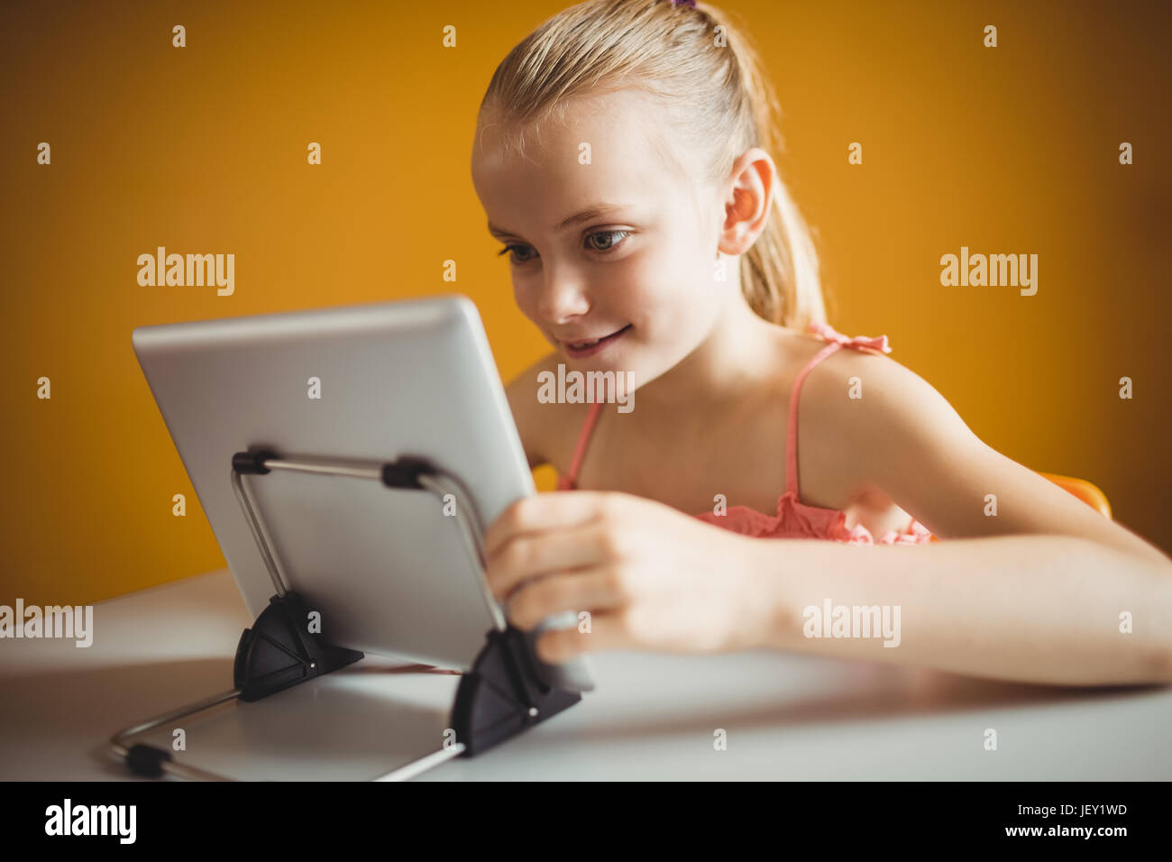 Seated girl using digital tablet Stock Photo - Alamy
