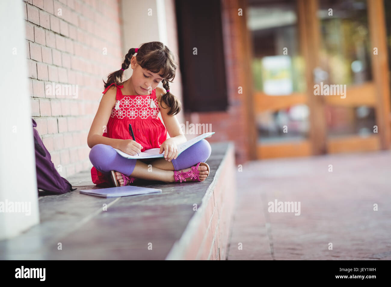 Girl writing in a book Stock Photo - Alamy
