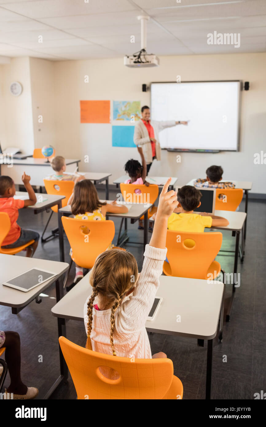Teacher giving lesson to her students Stock Photo - Alamy