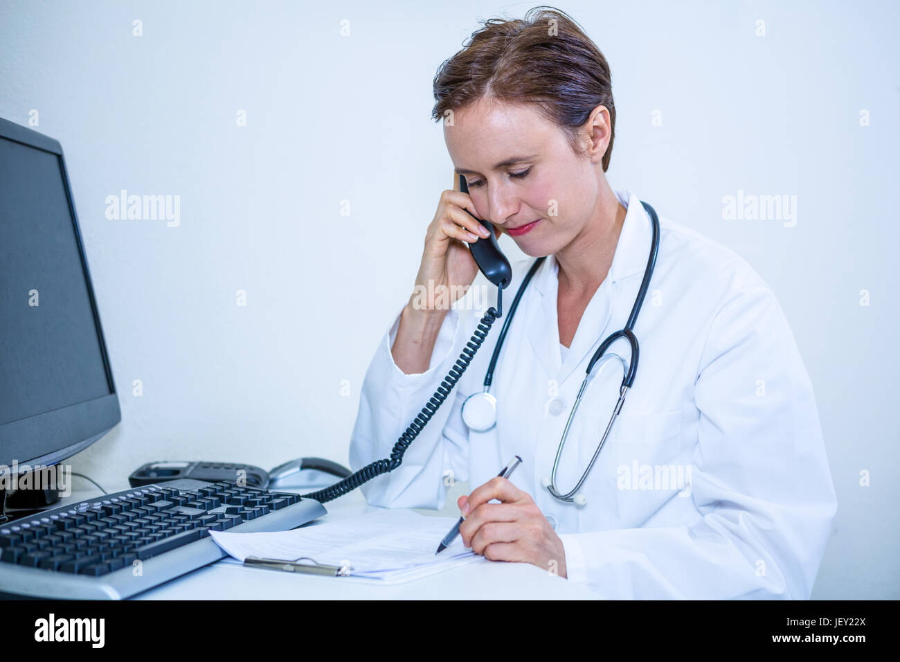 A thoughtful woman vet calling Stock Photo - Alamy