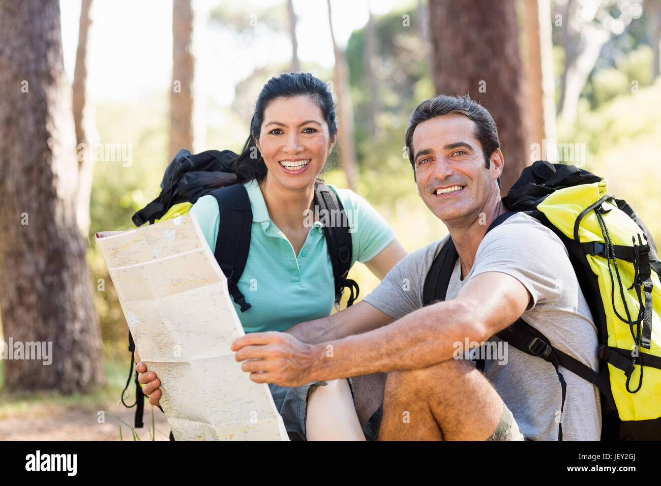 Couple smiling and holding a map Stock Photo - Alamy