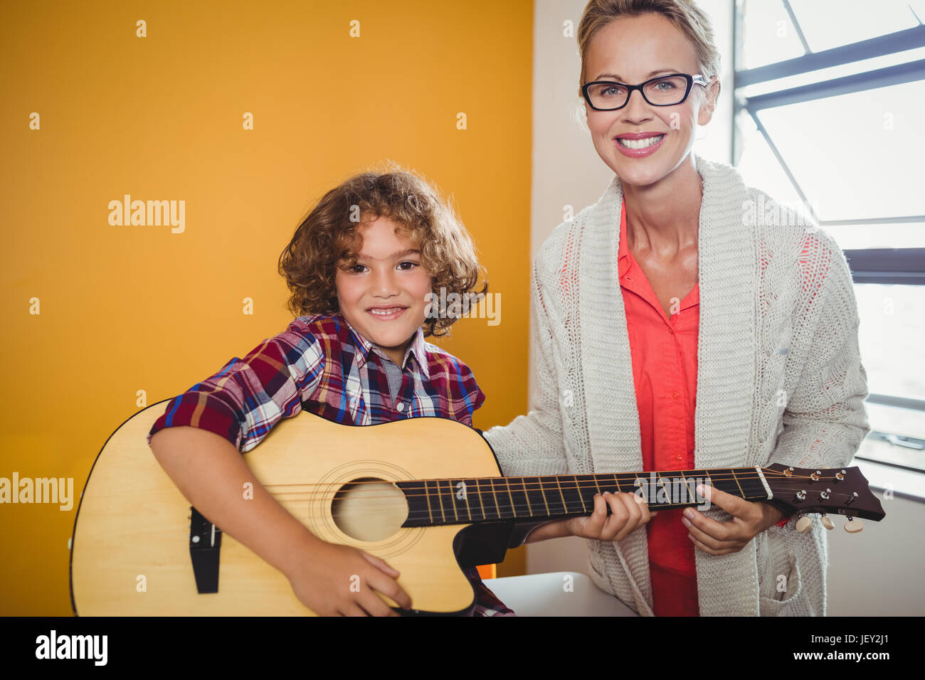 Boy learning how to play the guitar Stock Photo - Alamy