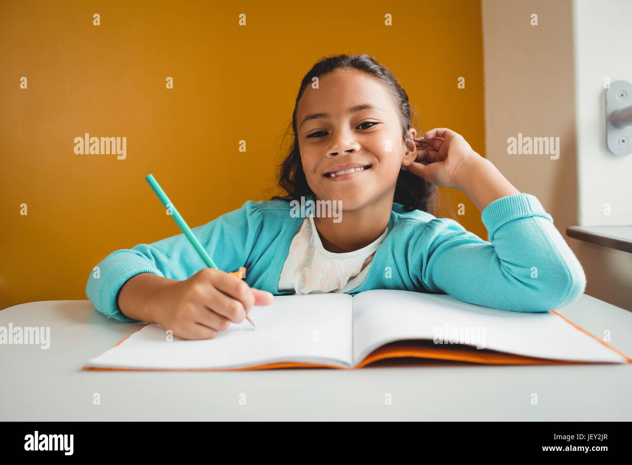 Girl writing in her notebook Stock Photo - Alamy