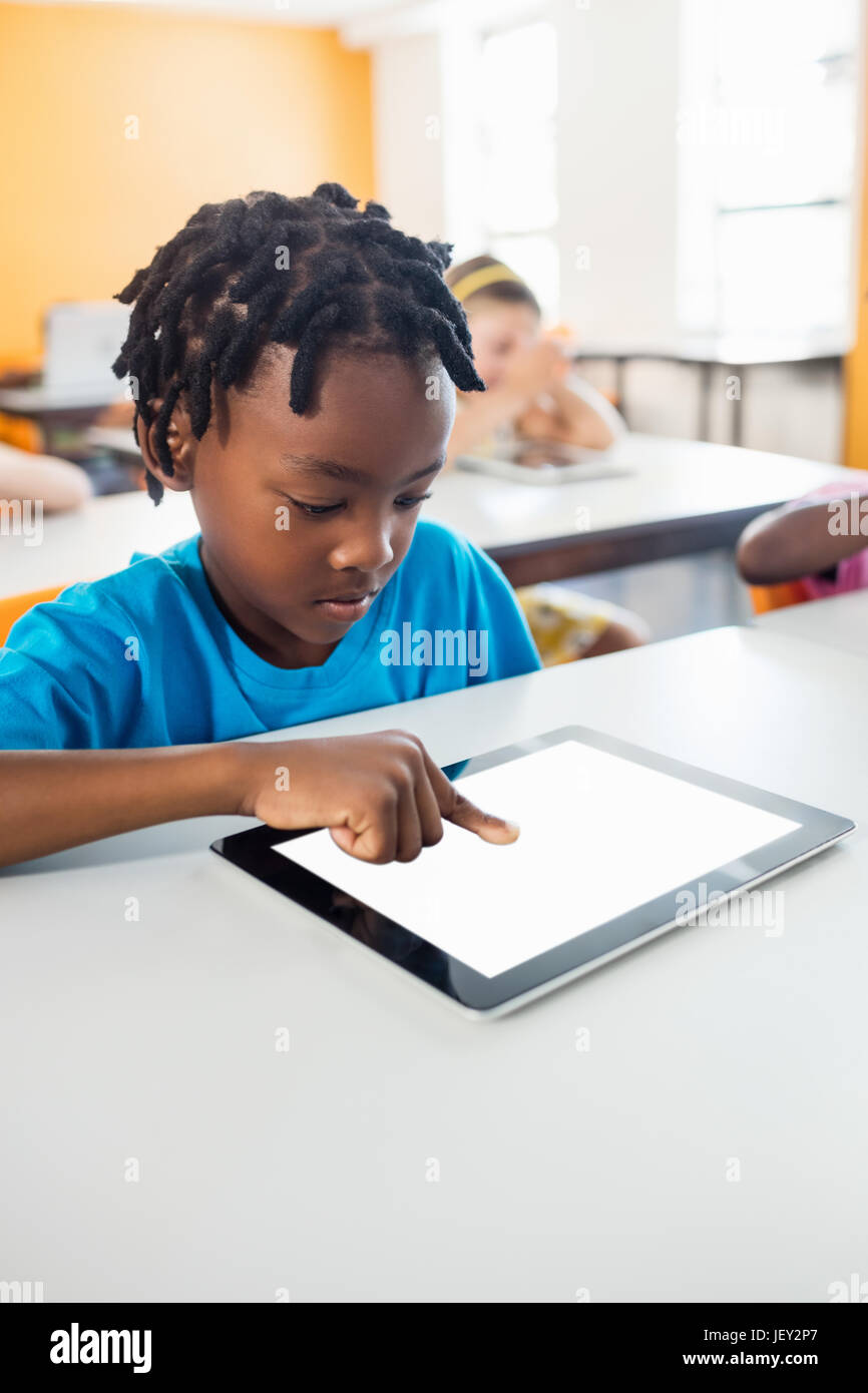 Little boy studying with tablet in classroom Stock Photo - Alamy