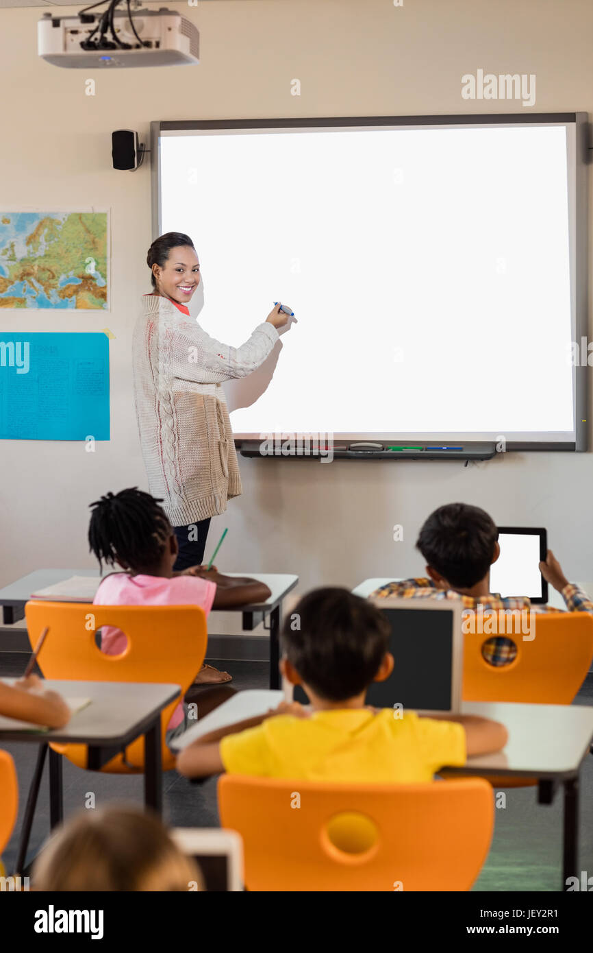 Teacher giving lesson to her students Stock Photo - Alamy