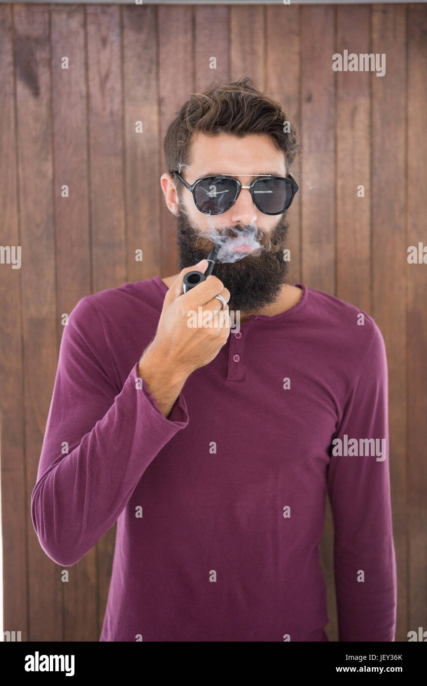 Hipster man smoking the pipe Stock Photo - Alamy