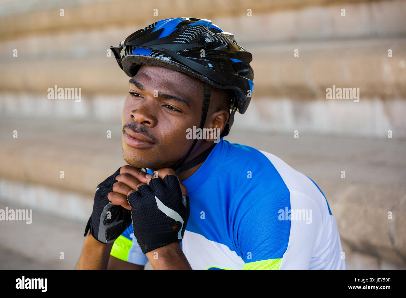 Athlete putting on cycling helmet Stock Photo - Alamy