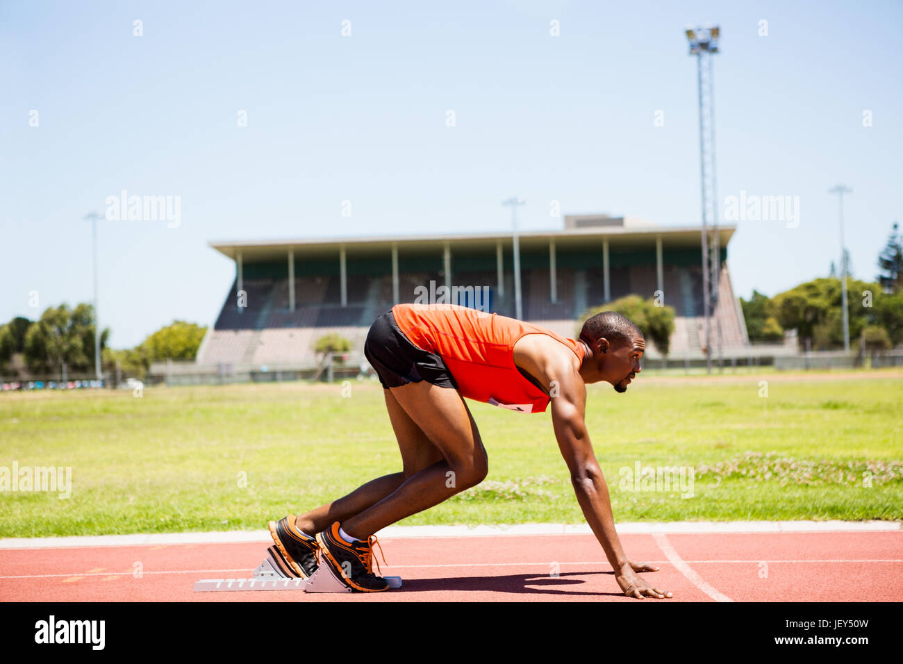 Athlete on a starting block about to run Stock Photo - Alamy