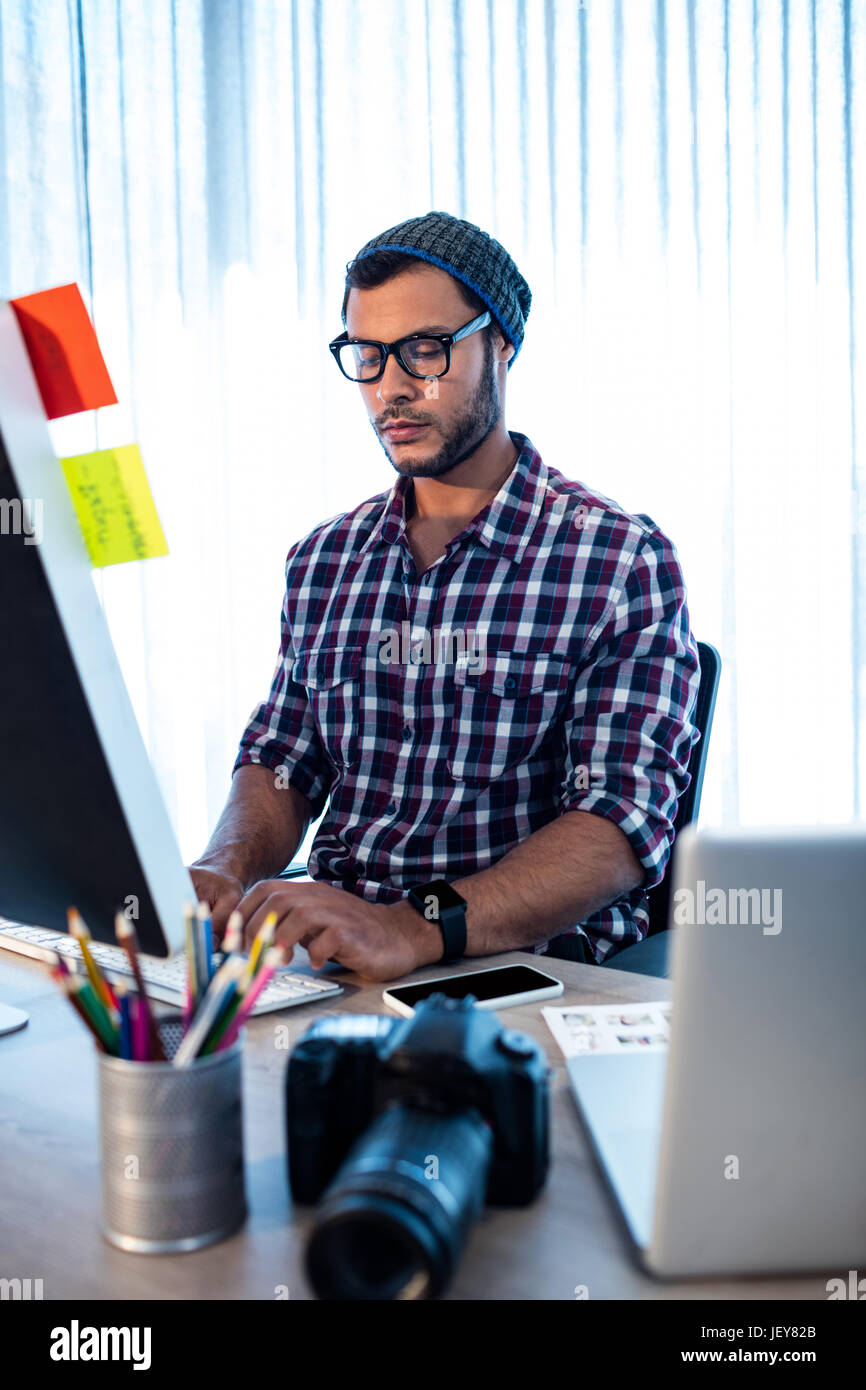 Photographer working at computer desk Stock Photo - Alamy