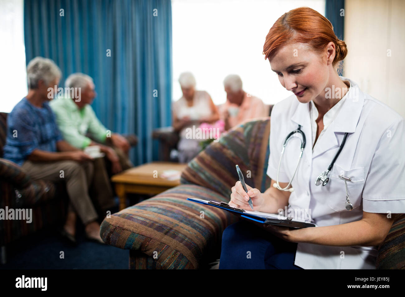 Nurse writing on a clipboard Stock Photo - Alamy