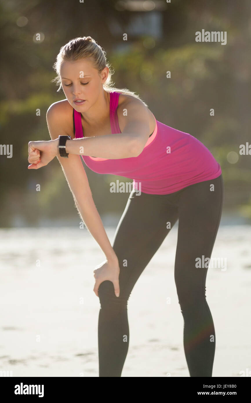 Woman checking time on beach Stock Photo - Alamy