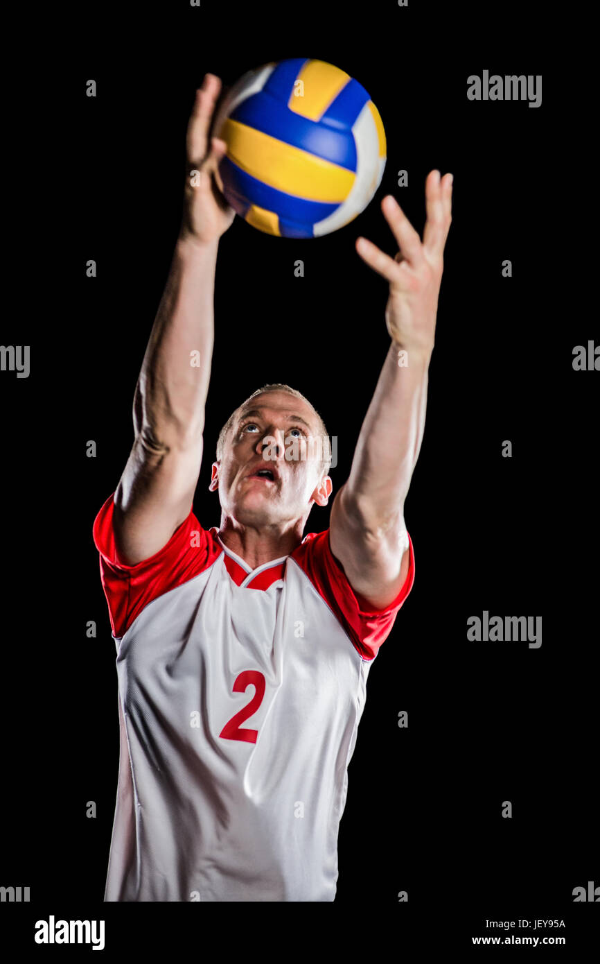 Sportsman catching a volleyball while playing Stock Photo - Alamy