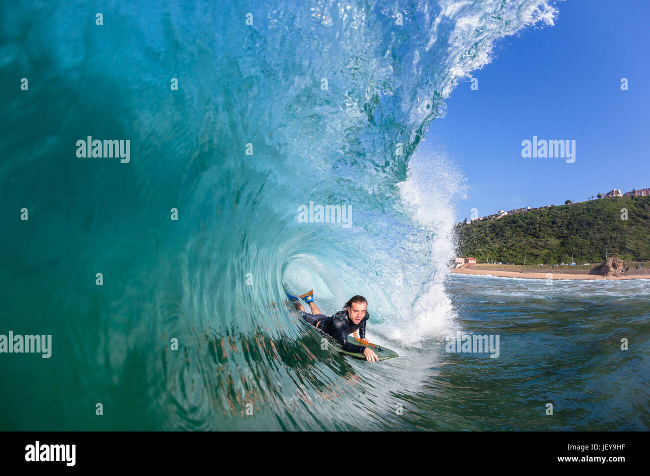 Surfer body boarder surfing hollow wave tube ride closeup up water ...