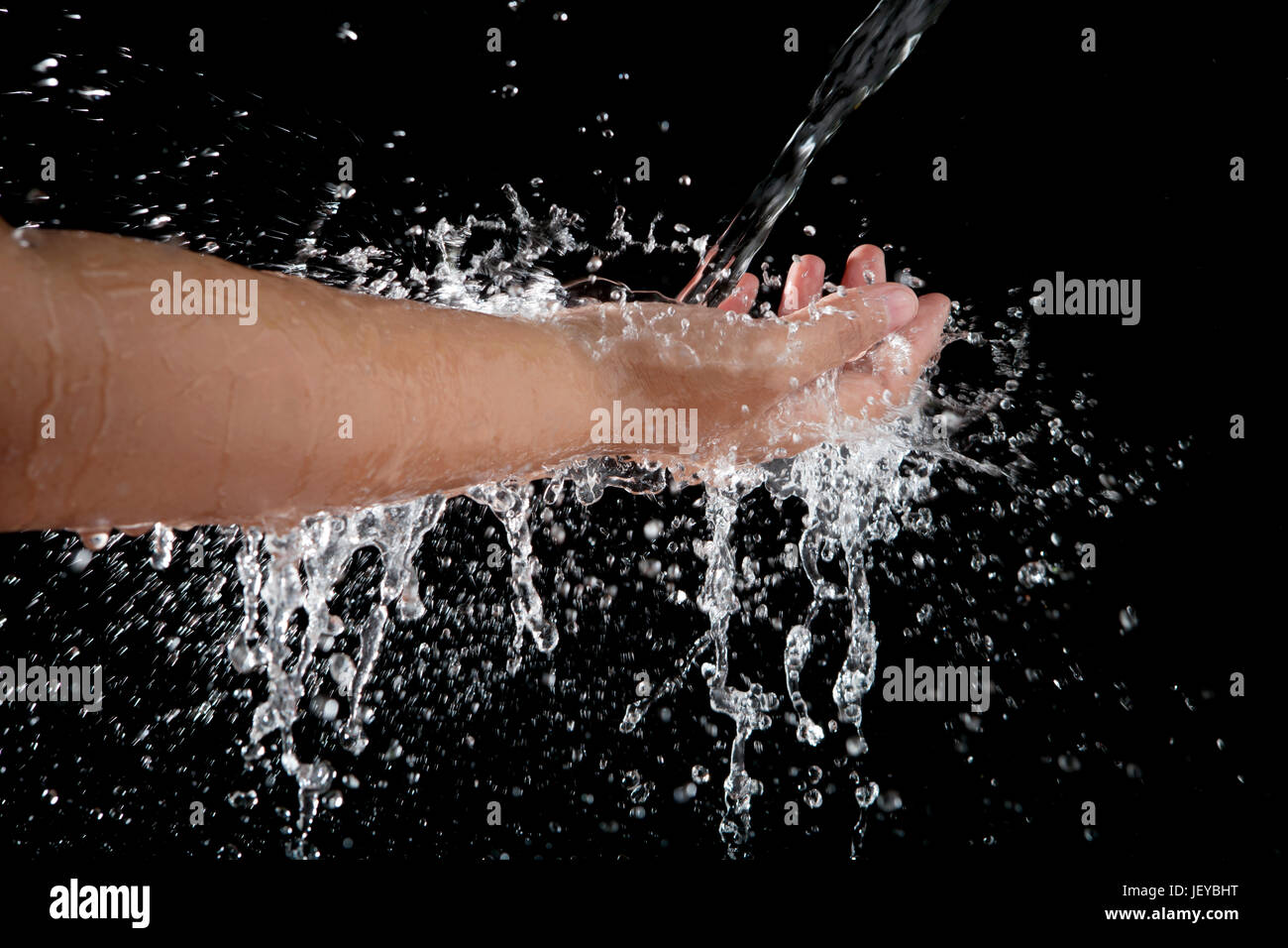 hand and pouring water splashing on black background Stock Photo - Alamy
