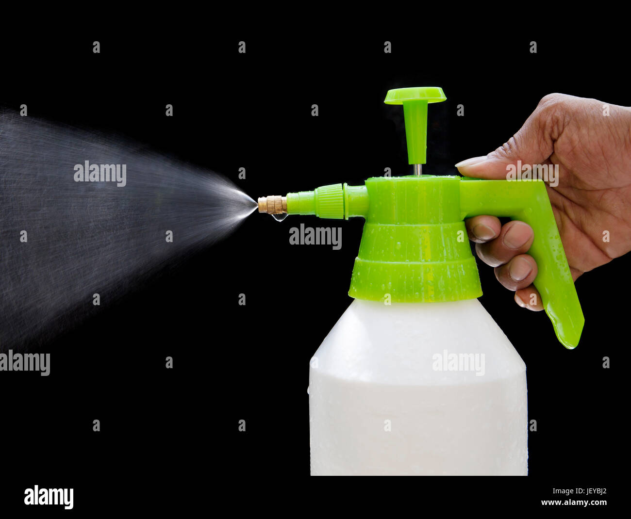 fresh water spray from bottle by hand isolated on black Stock Photo - Alamy