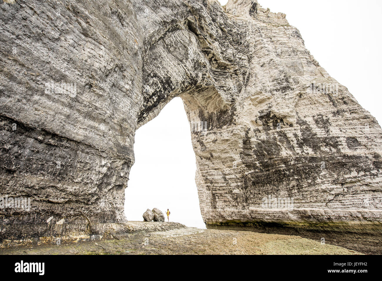 Landscape view on the huge stone cliff with a hole and traveler ...