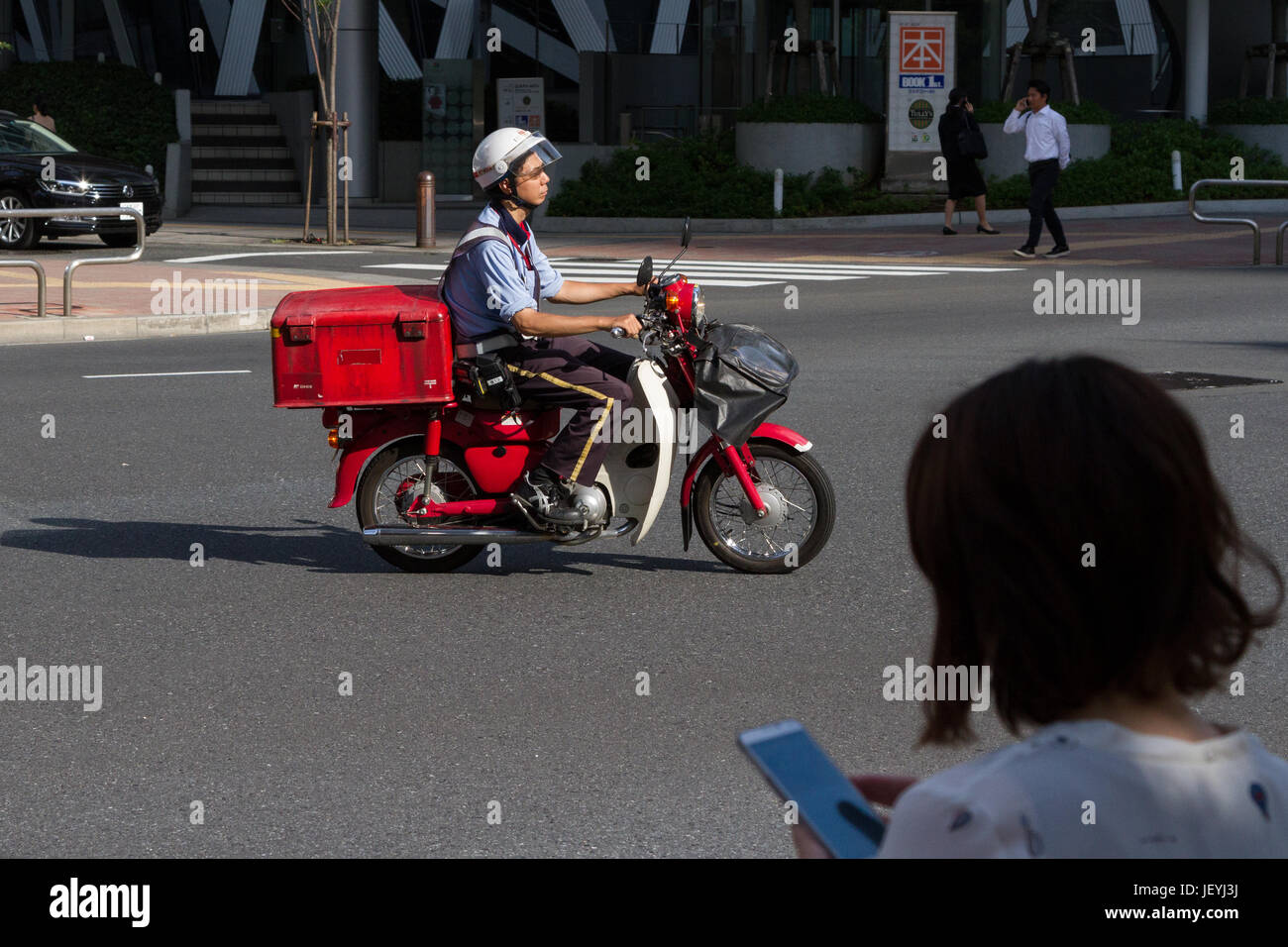 A Japanese postal worker on a scooter in Shinjuku, Tokyo, Japan Stock ...
