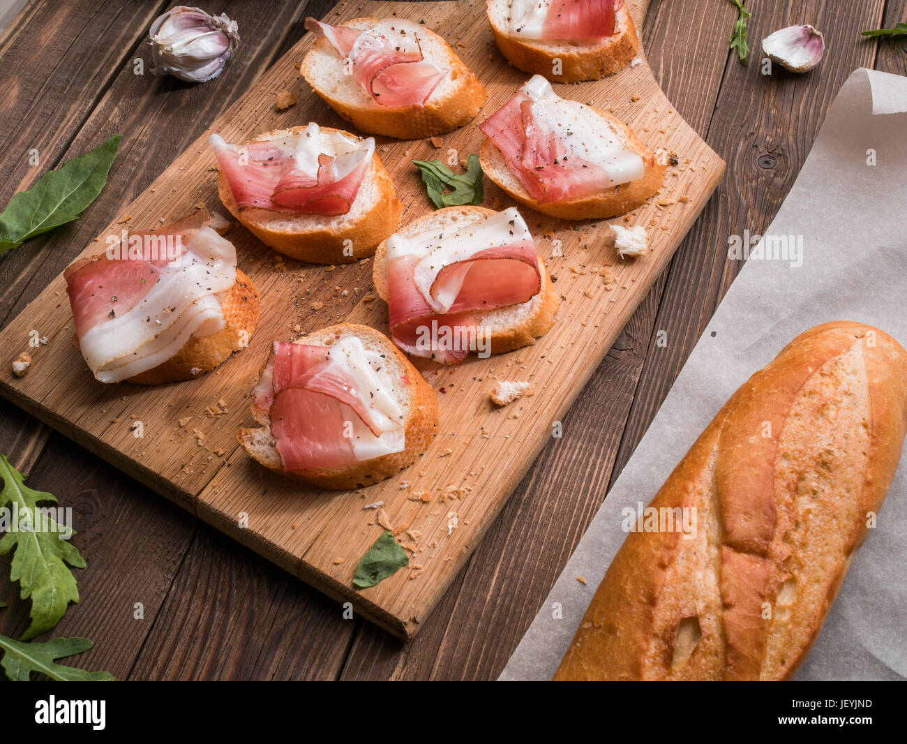 Appetizing bread with bacon on wooden board with greens Stock Photo - Alamy