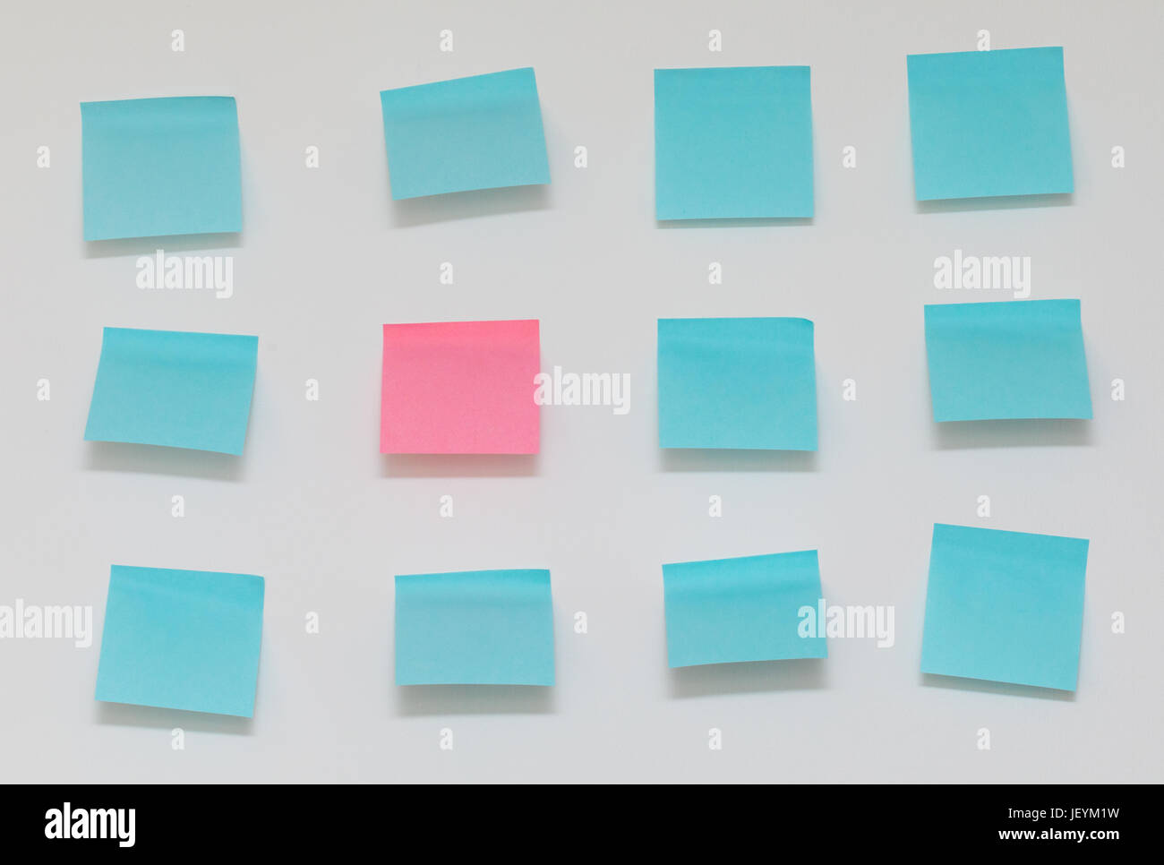 Single pink post it note in sea of blue post it notes Stock Photo - Alamy