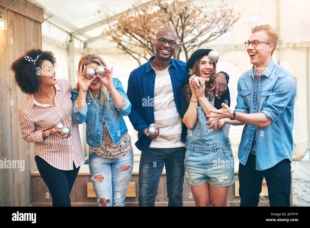 Smiling emotional group of black and white friends looking at man ...