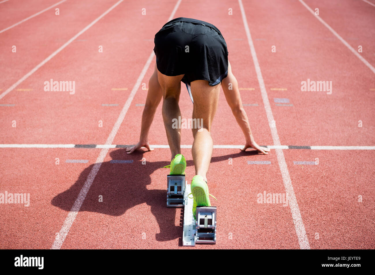 Rear view of an athlete ready to run Stock Photo - Alamy