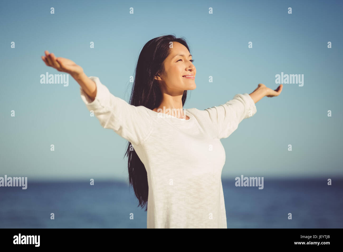 Woman standing with arms outstretched Stock Photo - Alamy
