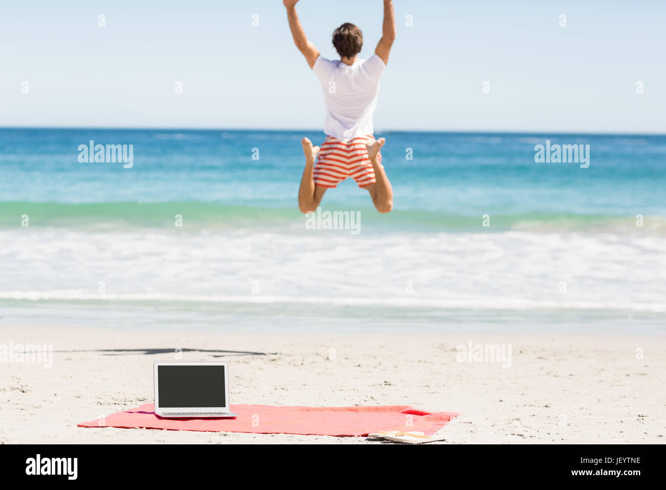 Man jumping on beach Stock Photo - Alamy
