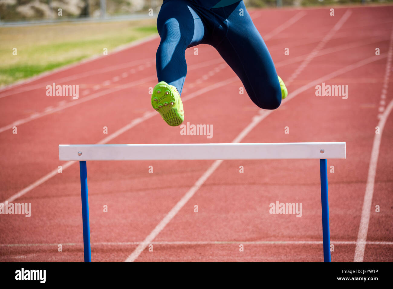 Athlete jumping above the hurdle Stock Photo - Alamy