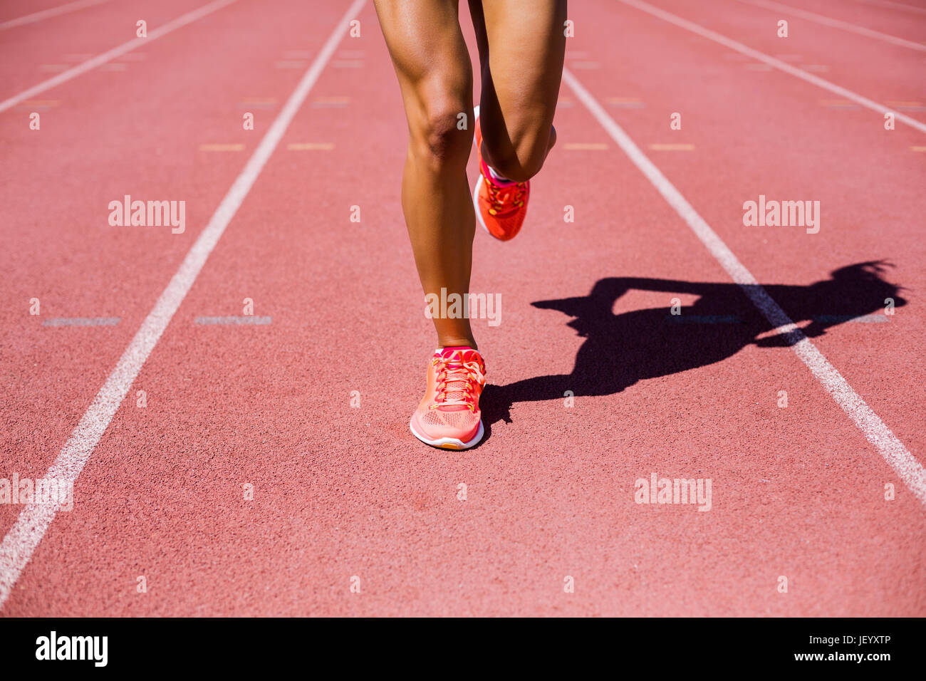 Female athlete running on the racing track Stock Photo - Alamy