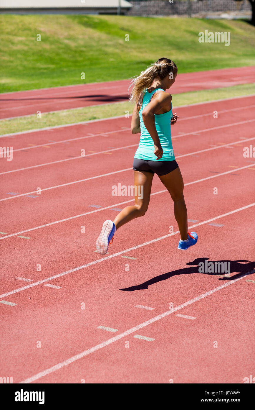Female athlete running on the racing track Stock Photo - Alamy