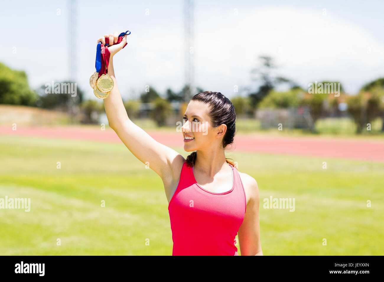 Happy female athlete showing her gold medals Stock Photo - Alamy